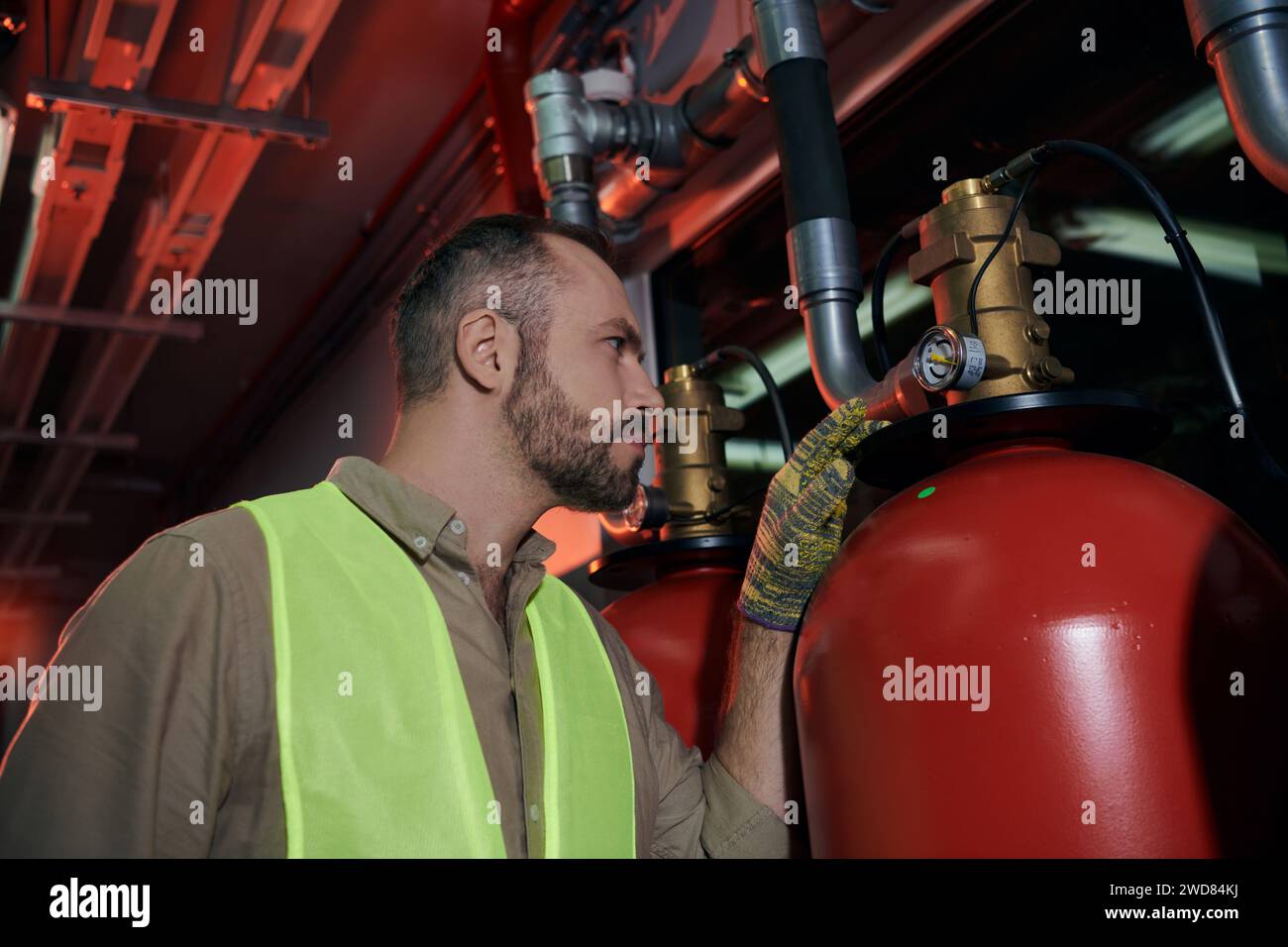 good looking focused technician in safety clothes checking gas ...