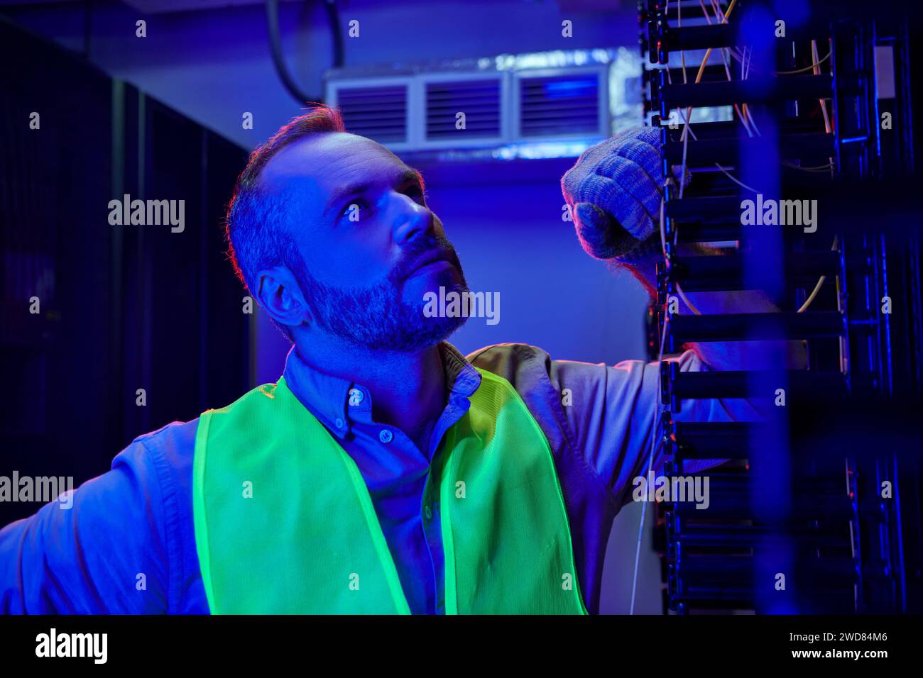 hardworking jolly specialist in safety vest and gloves inspecting ...