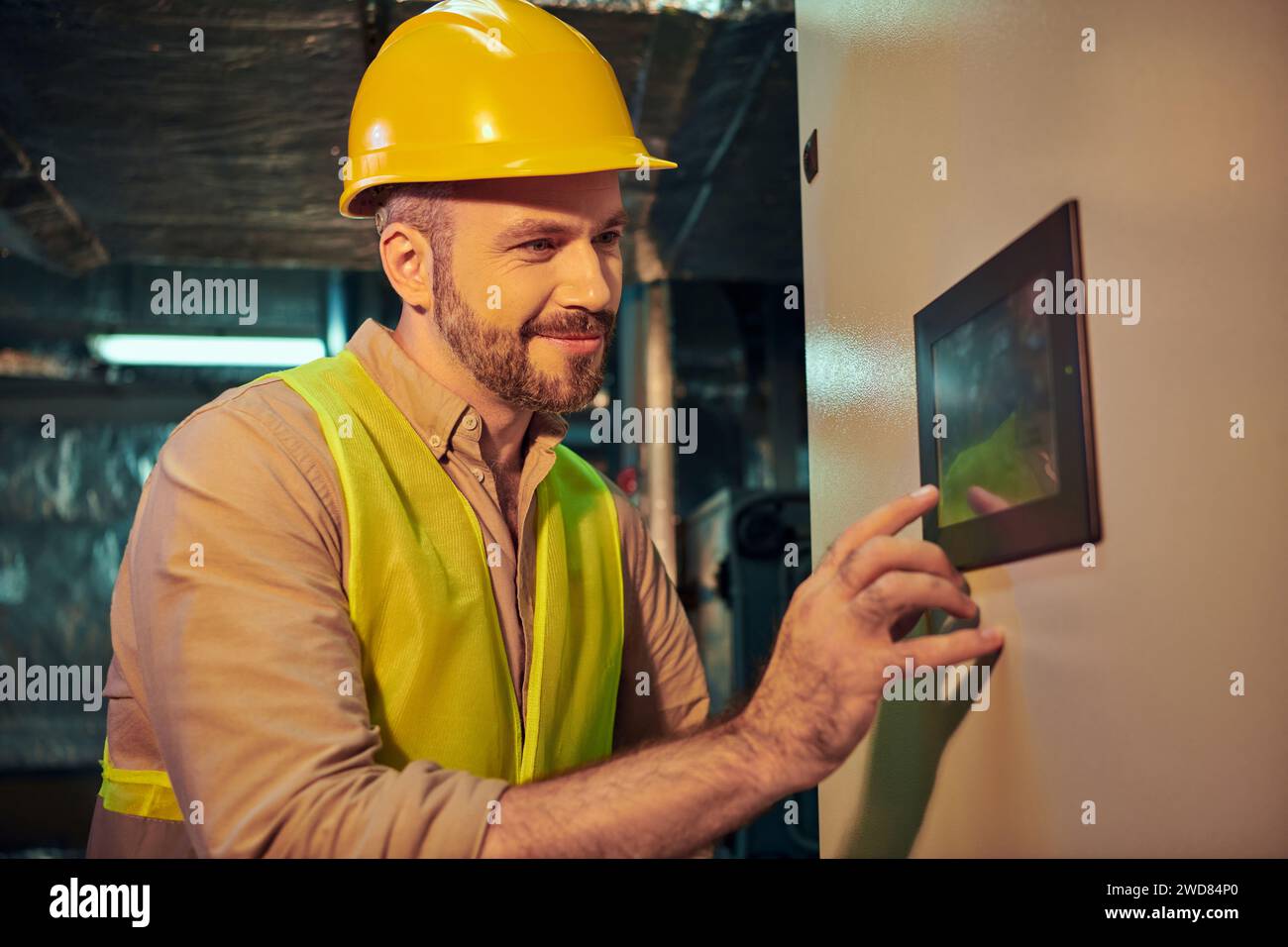 cheerful technician in safety clothes and helmet working hard and ...