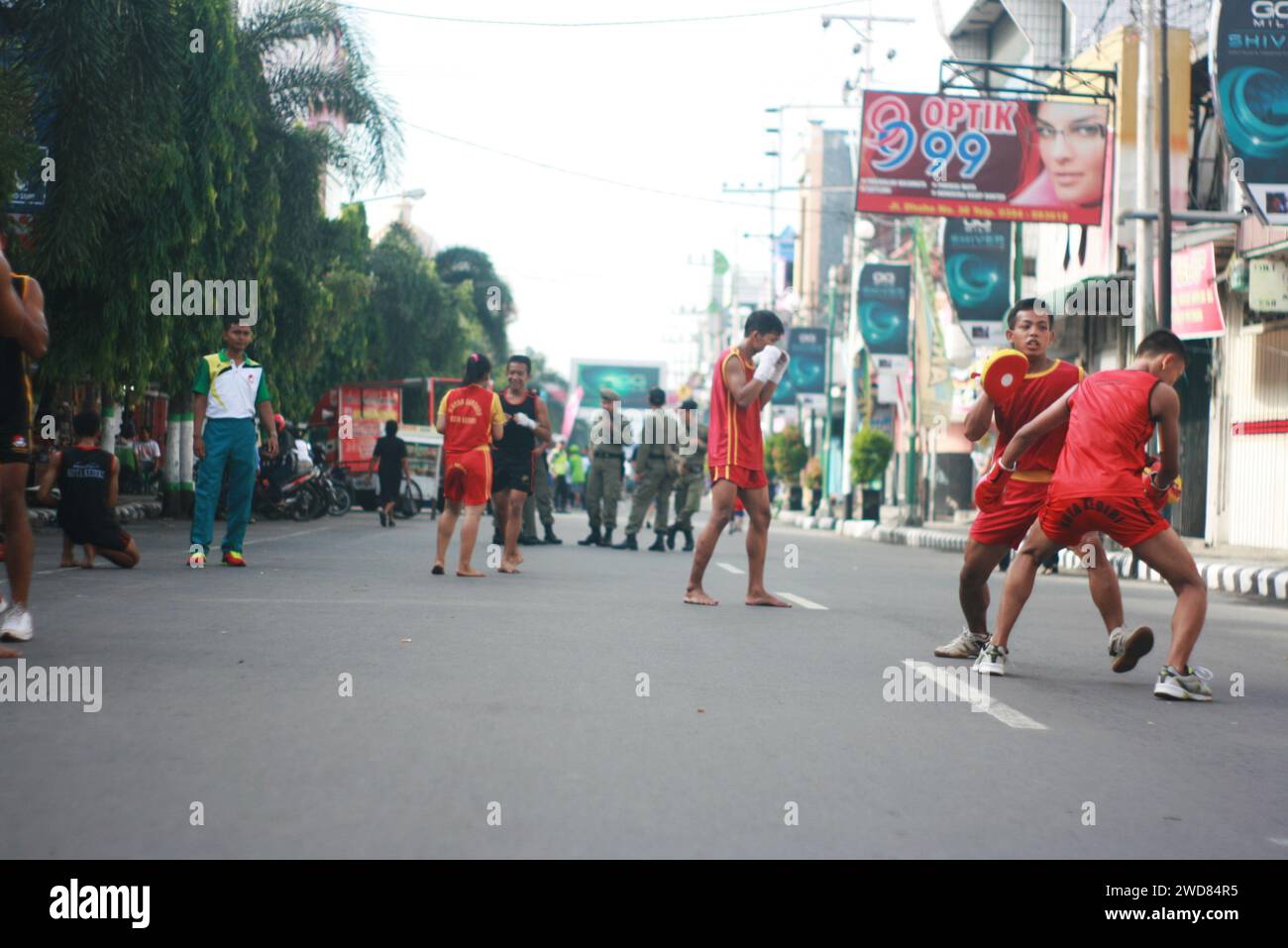a group of young men practicing boxing on Dhoho Street, Kediri during ...