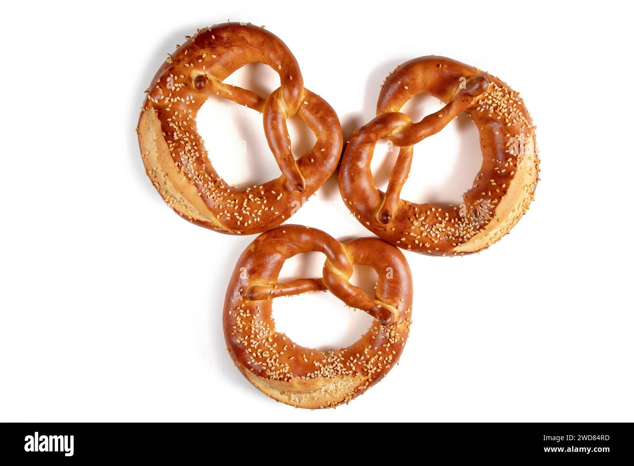 Three golden brown Bavarian pretzel top view with a generous amount of ...