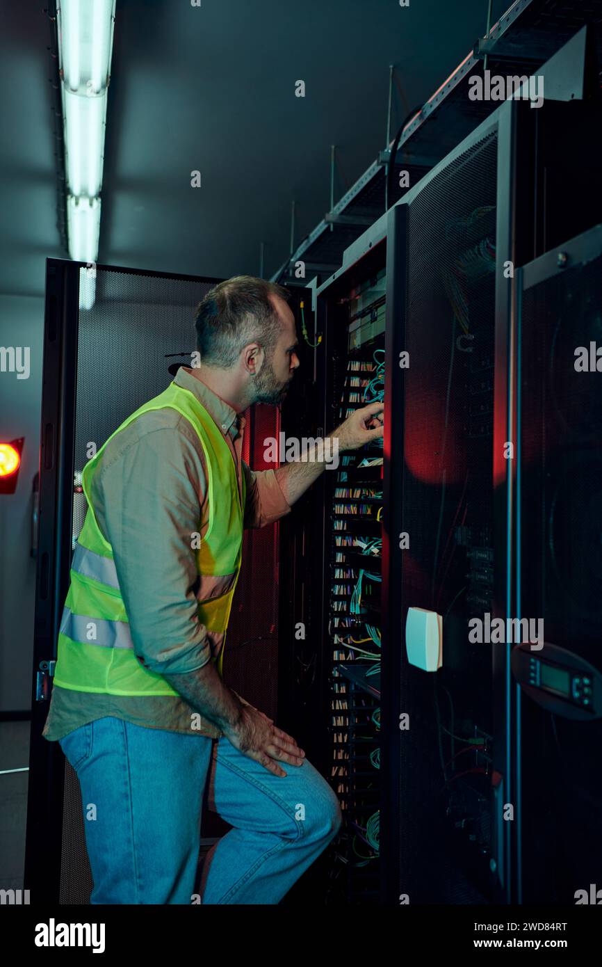 handsome technician with beard in safety vest inspecting data center ...