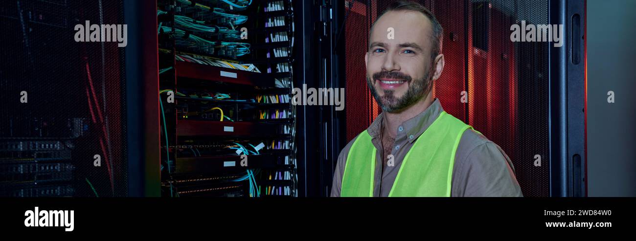 good looking jolly man in safety vest smiling at camera during ...