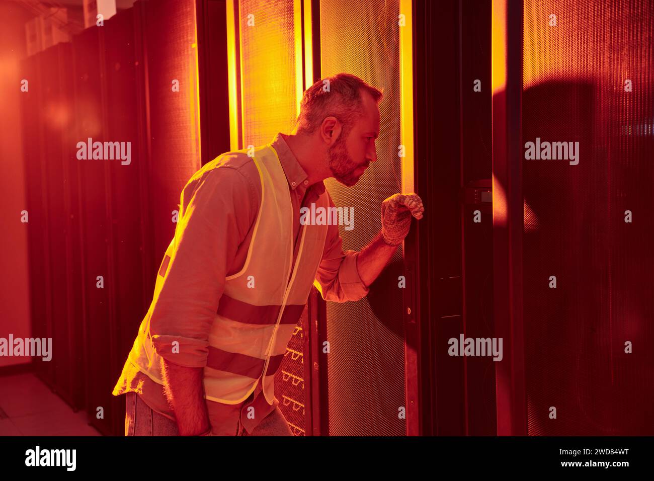 attractive devoted technician in safety vest and gloves working ...