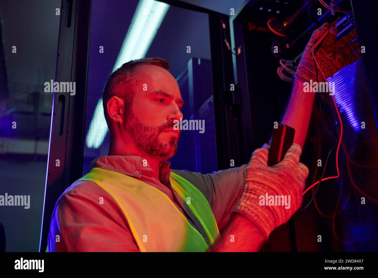 handsome hardworking professional in safety vest and gloves checking ...