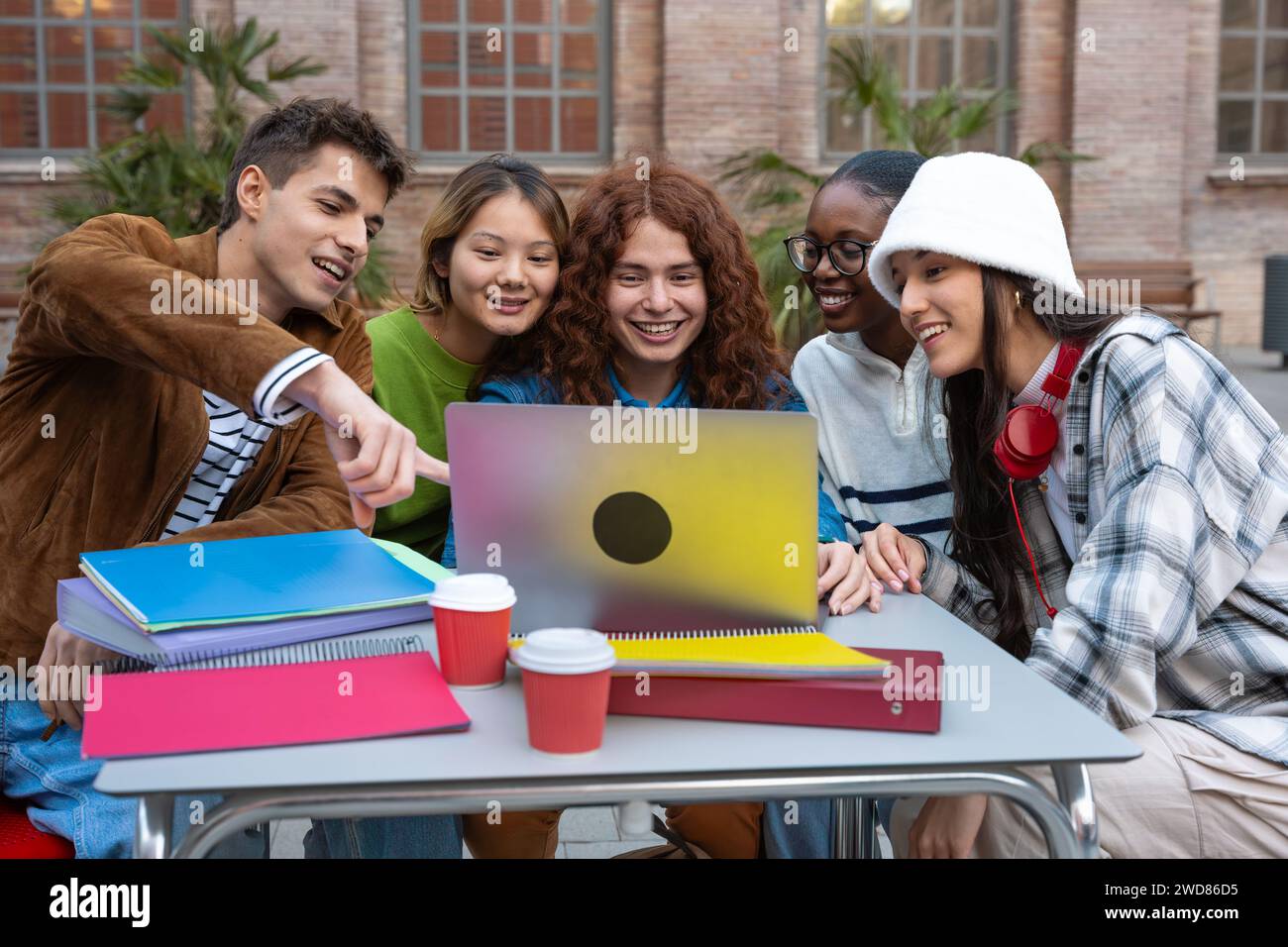 A group of multiracial students with laptops sit near campus to study outdoors Stock Photo - Alamy