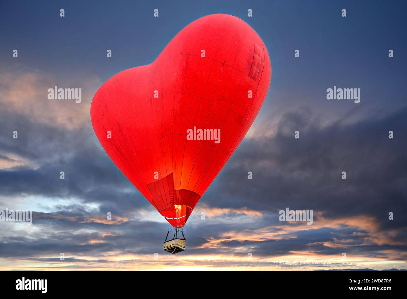 Red heart shaped hot air balloon flying over sunset sky Stock Photo - Alamy
