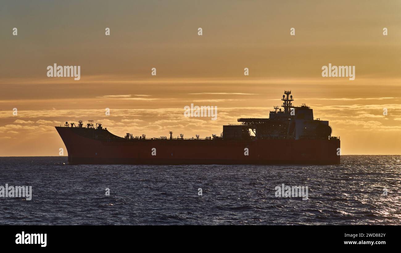 Beautiful ocean sunset, with golden sky, dark blue sea and silhouette ...