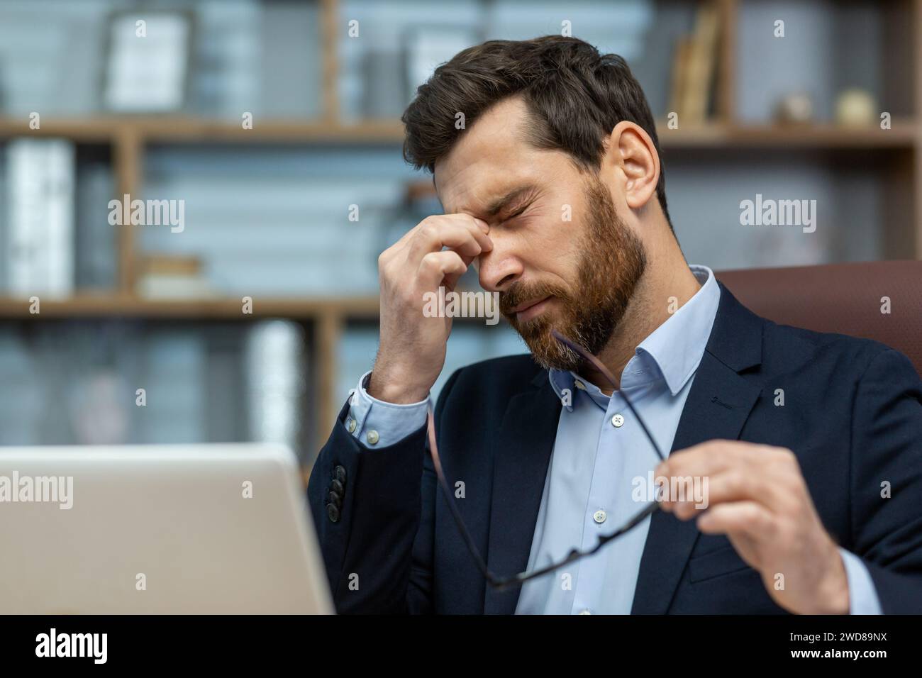 Serious mature man in business attire feeling fatigued, rubbing his ...
