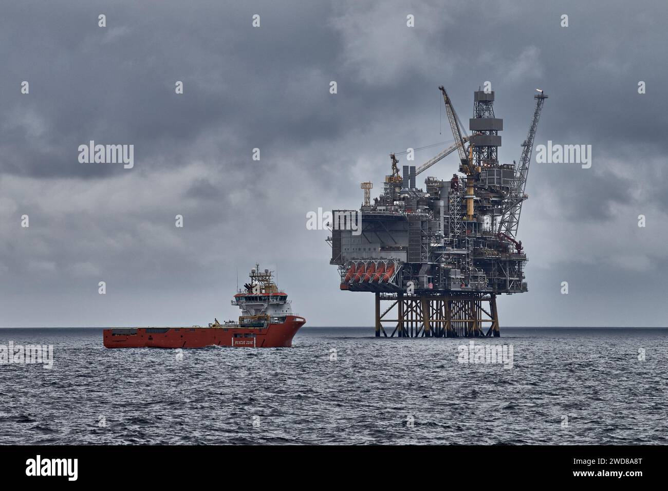 Panoramic view of Jack up drilling rig and supply vessel on a dark ...