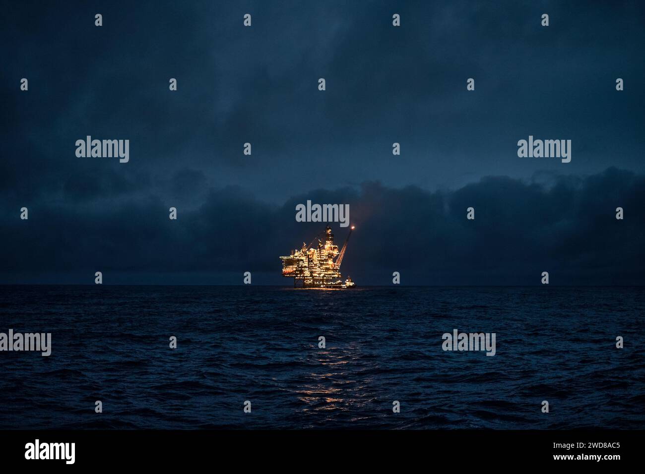 Panoramic view of offshore oil filed in the sea at night, with oil and ...