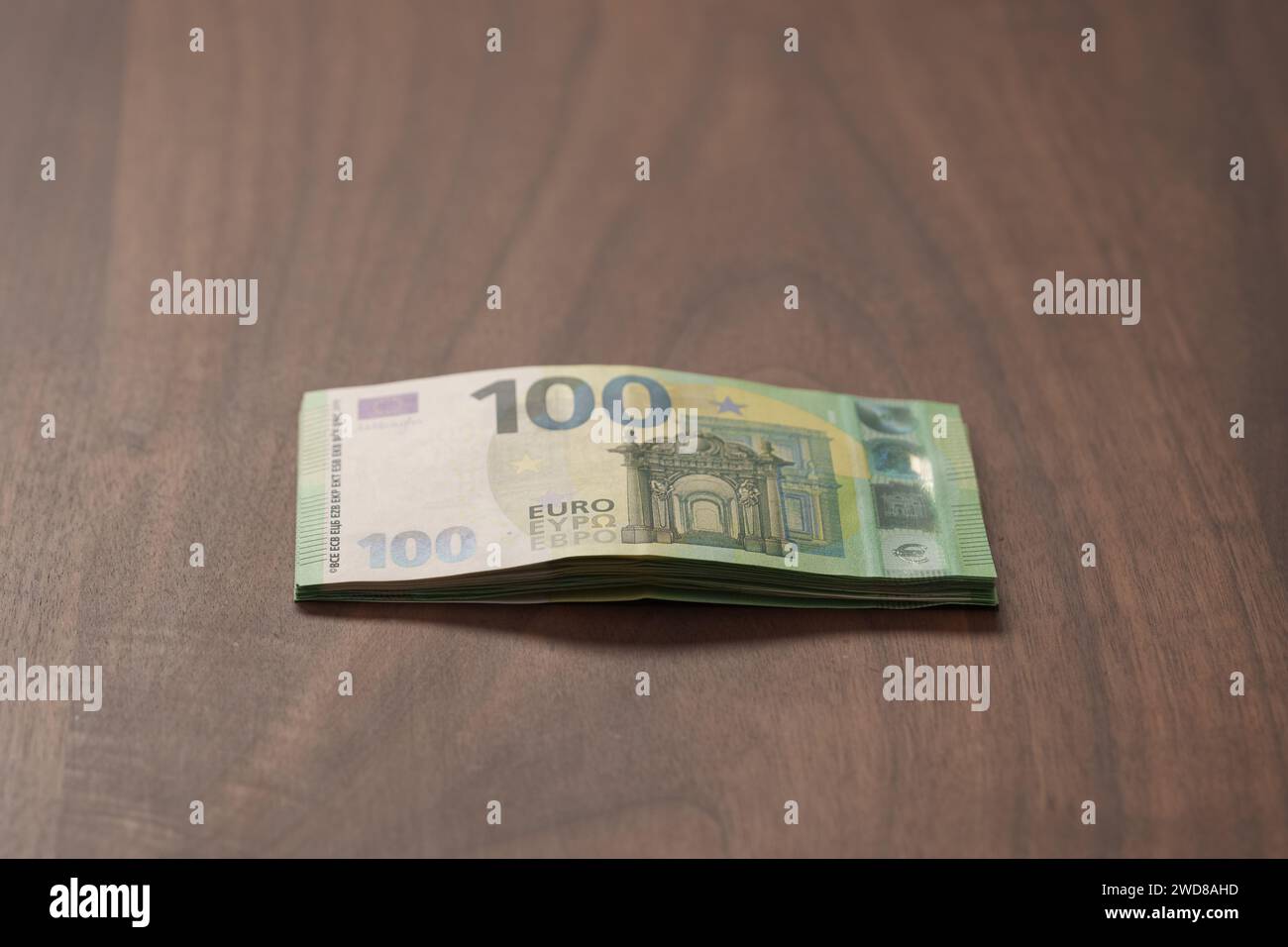 Hundred euro banknotes on a walnut table. shallow focus Stock Photo - Alamy