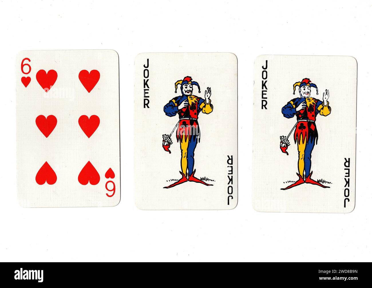 Vintage playing cards showing a pair of jokers and a red six isolated ...