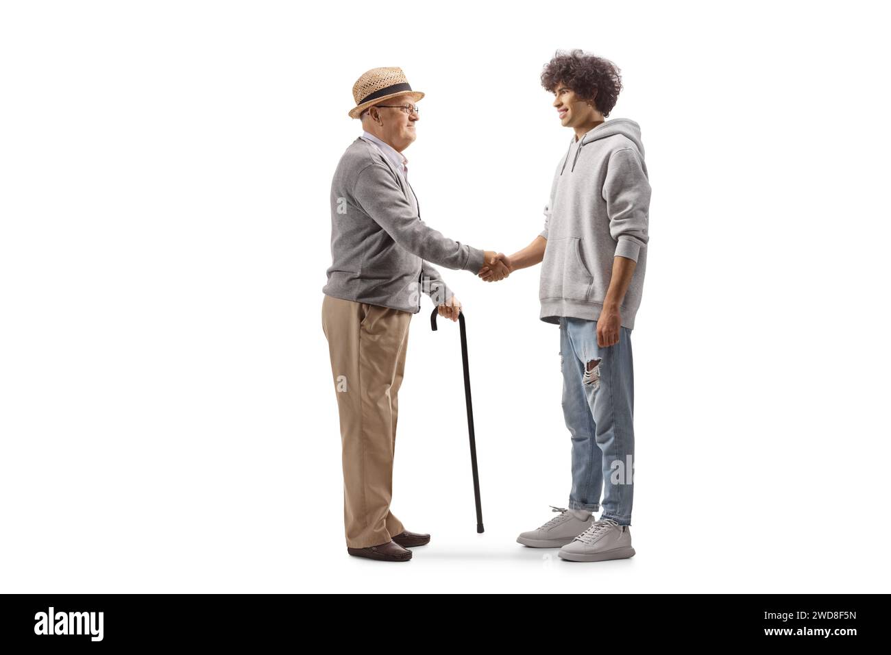 Elderly man meeting a young man and shaking hands isolated on white ...