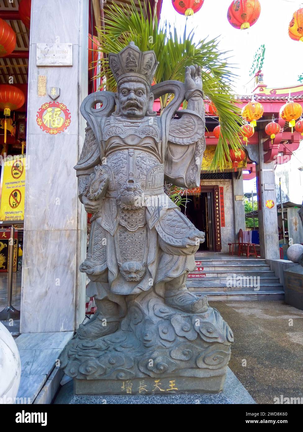 Stone statue of deity guarding entrance to temple Jui Tui Tao Boh Kaeng ...