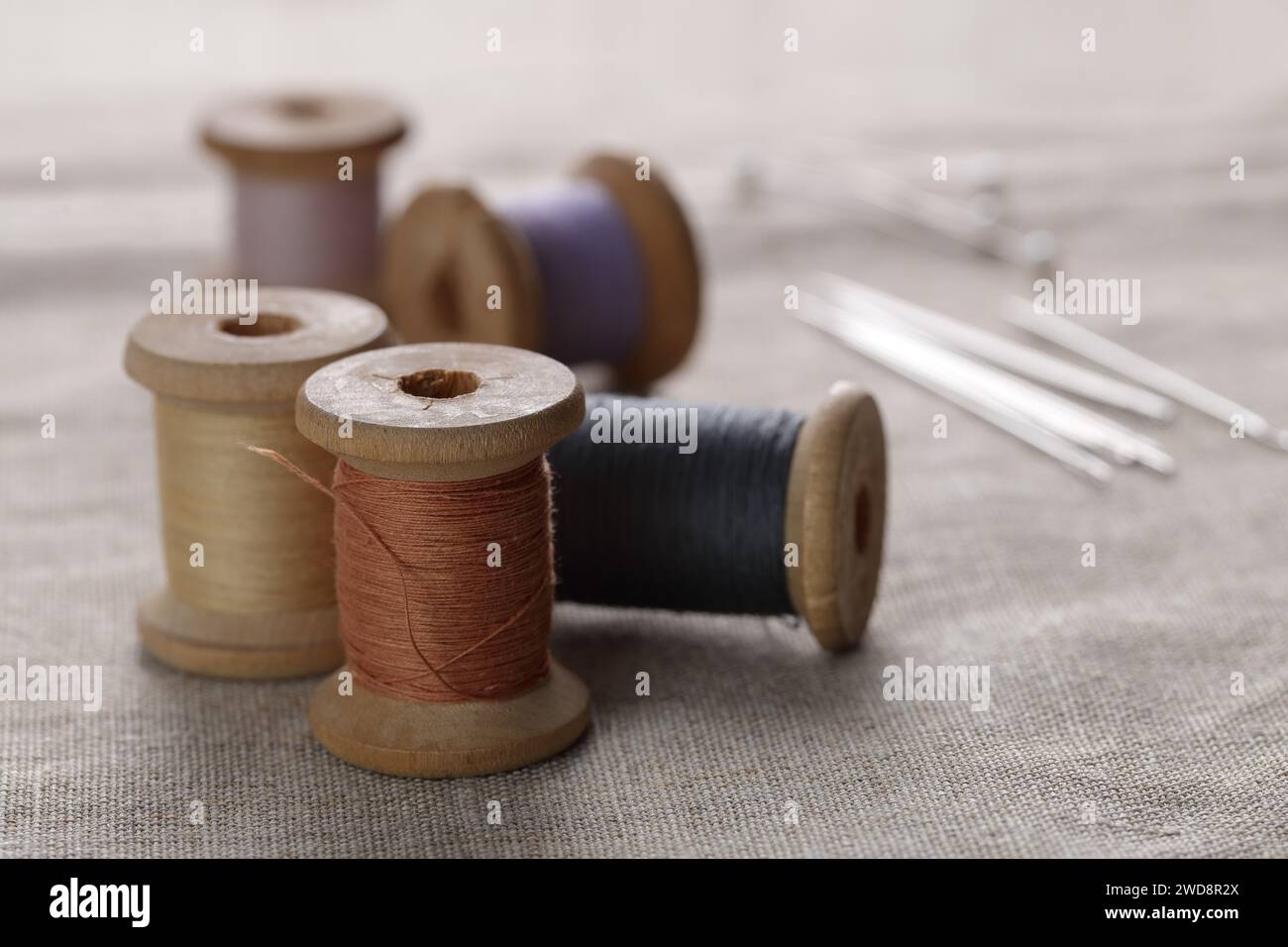 Spools of thread and a needles on a canvas Stock Photo - Alamy