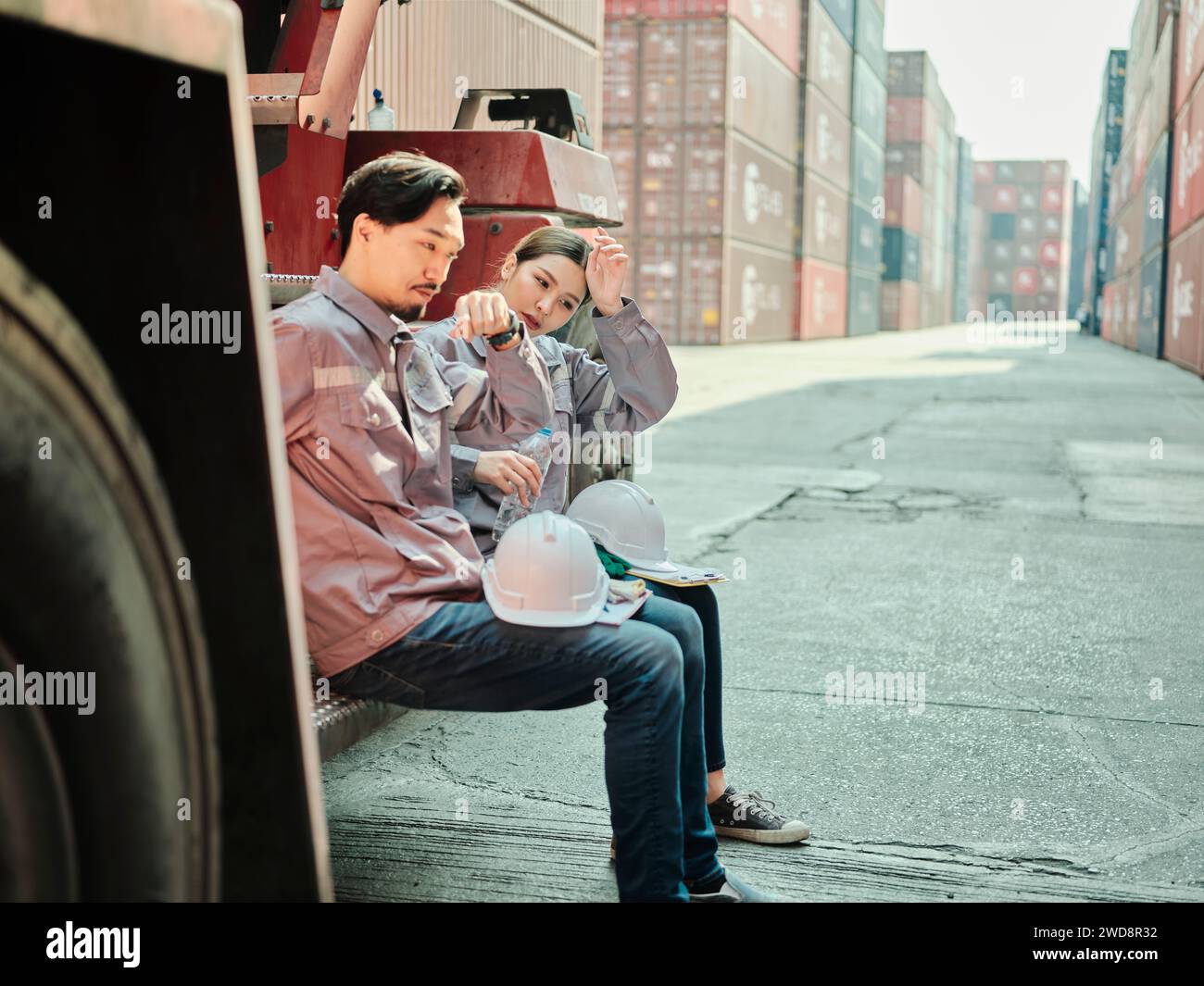 A team of engineers resting relax time and drinking water , a hard day's work at container ...