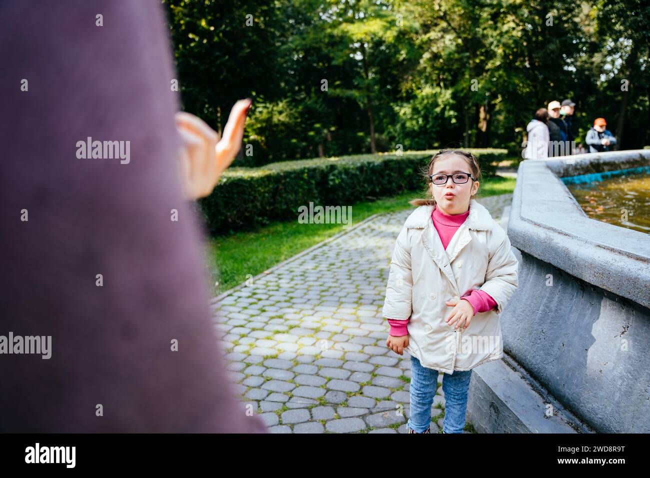 Portrait sad down syndrome girl standing in front of her mother with a ...