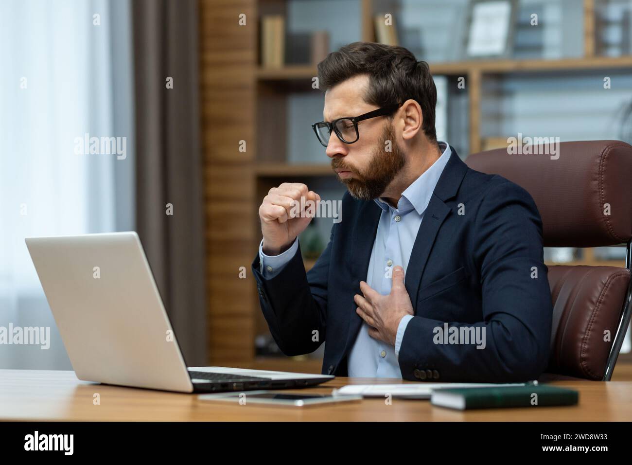 Concerned mature businessman feeling chest pain while working at his ...