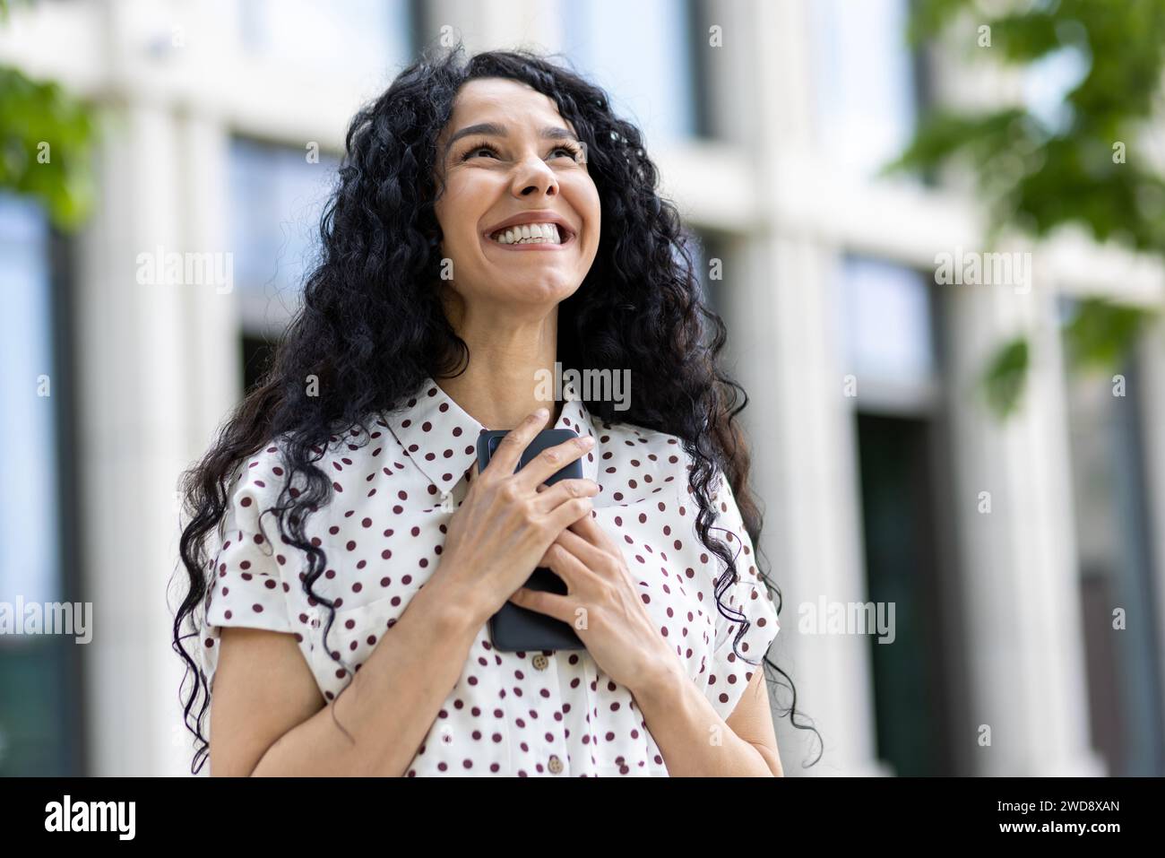 Optimistic young Latin American woman with curly hair smiling outside ... Optimistic young Latin American woman with curly hair smiling outside ...