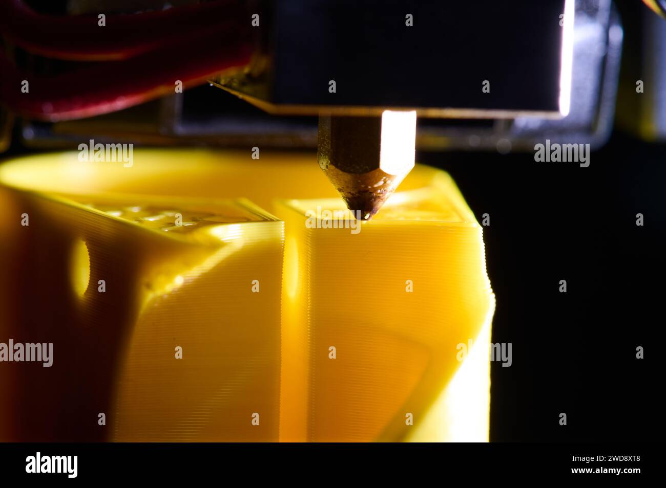 3D printer printing a part made of yellow plastic, close-up view Stock ...