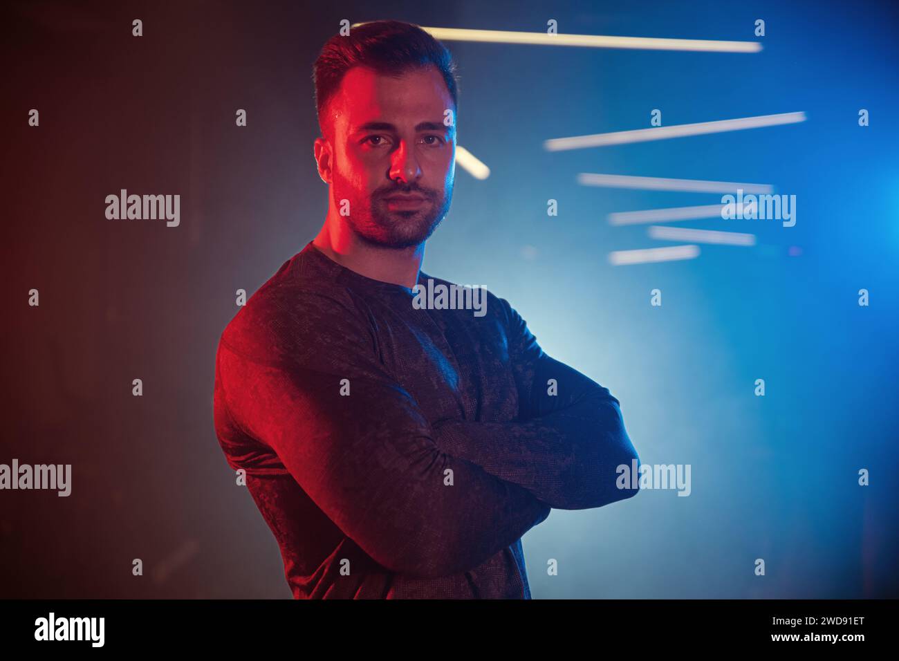 Portrait of a male athlete crossing his arms in a gym, highlighted by ...