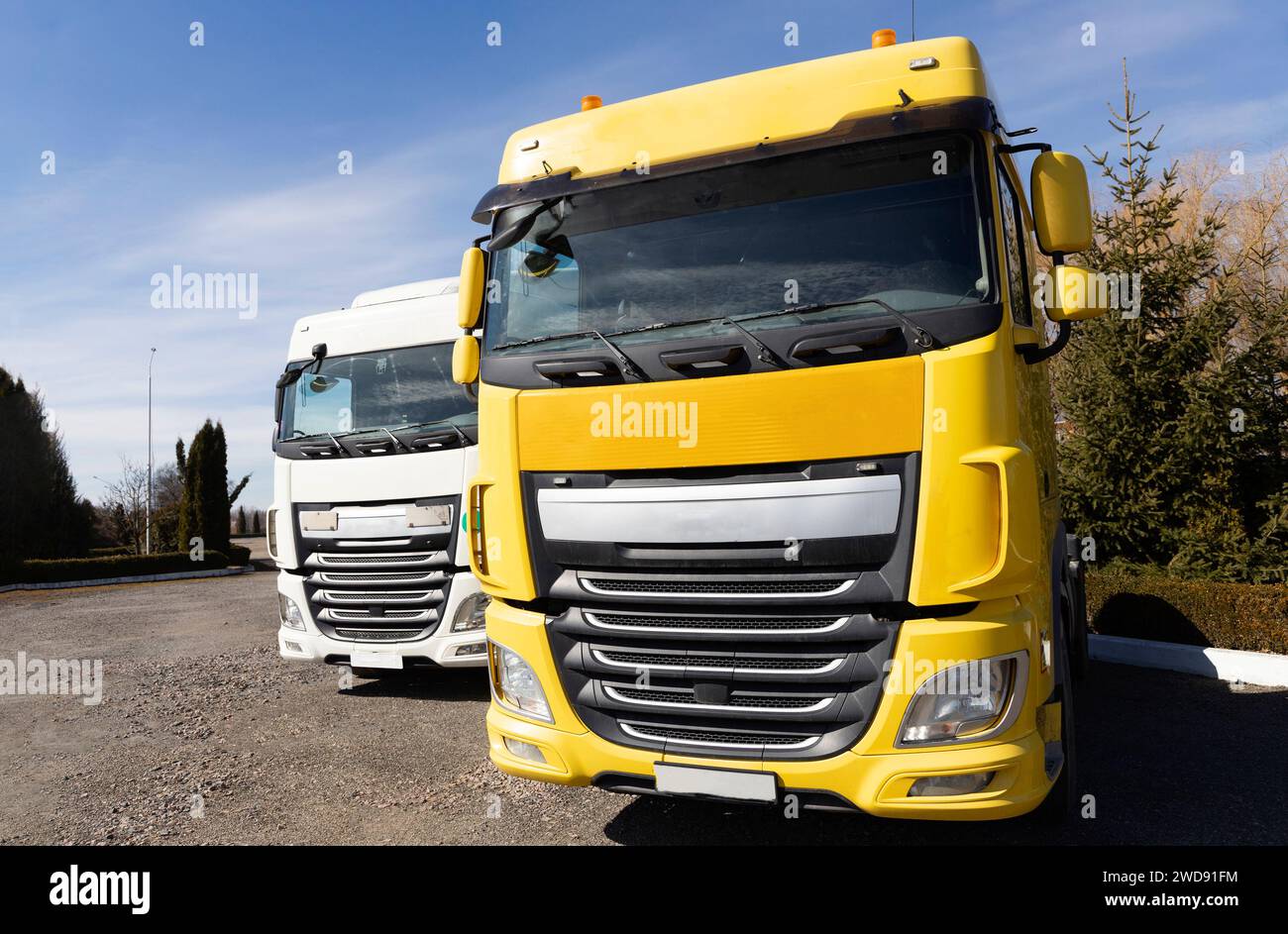 Yellow and white cab trailerless tractor in sunlight against the sky ...