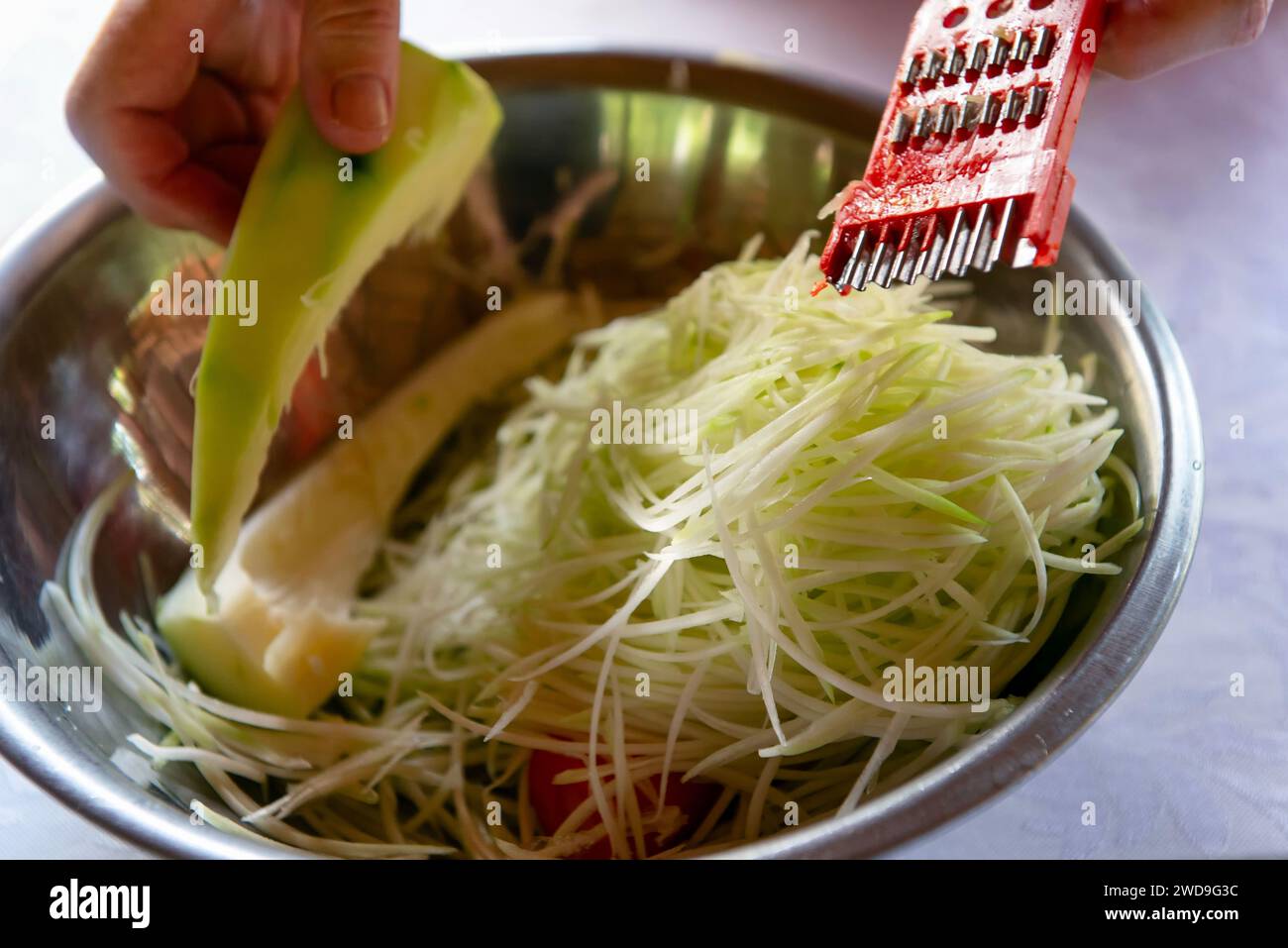 Bowl with grated green papaya for salad Stock Photo - Alamy