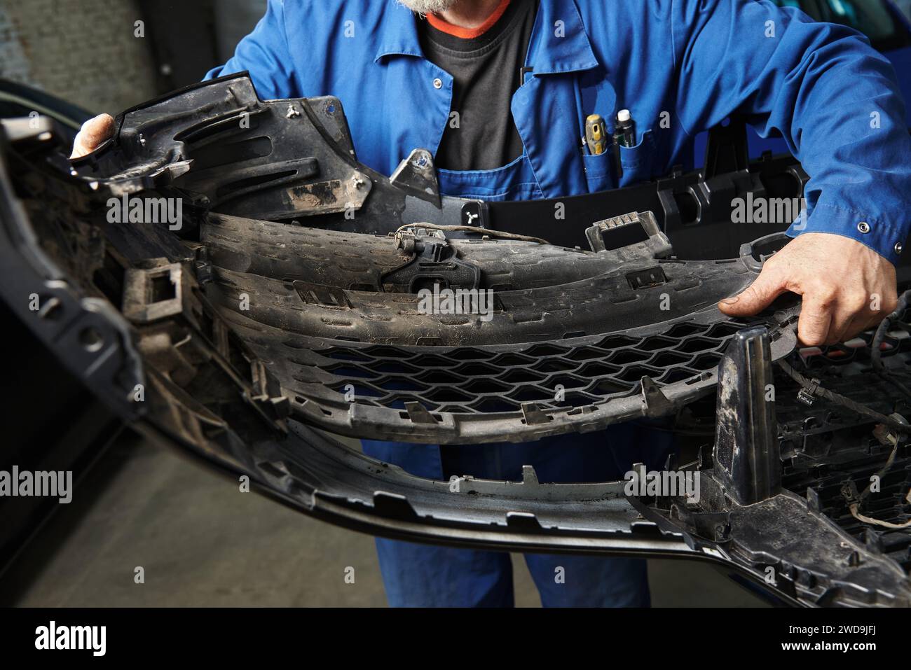 Hands of the master in cars and various car parts. Car engine, bumper ...