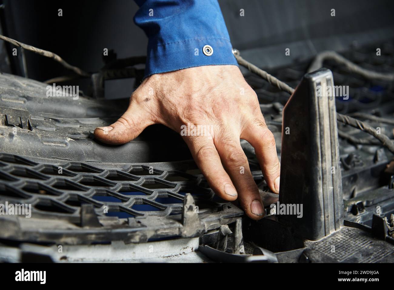 Hands of the master in cars and various car parts. Car engine, bumper ...