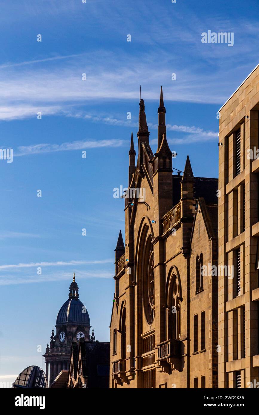 Buildings in late afternoon sunshine with blue sky behind in Leeds city ...