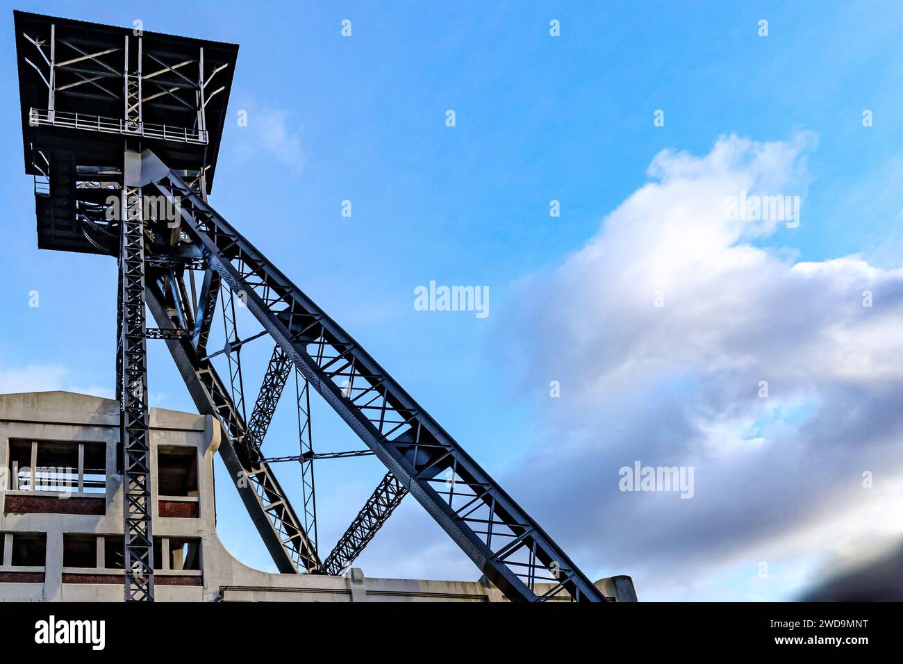 Top of disused shaft tower of former Waterschei coal mine against blue sky, metal tower ...