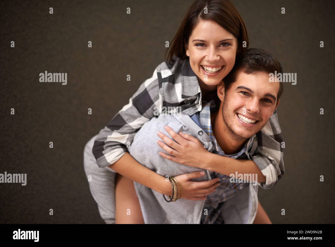 Studio, hug and portrait of happy couple, piggyback ride and having ...