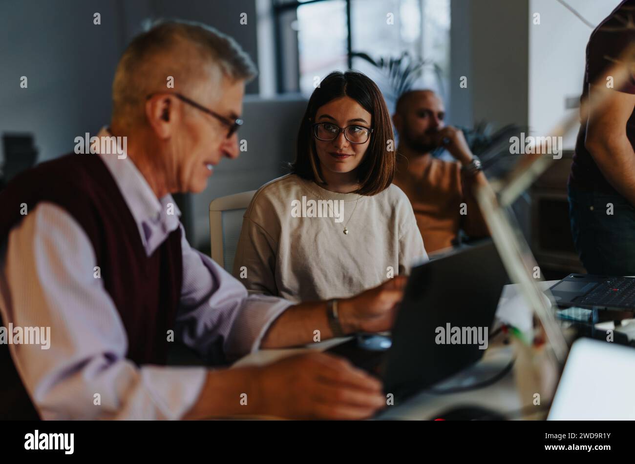 Cross generational colleagues discussing business growth strategy in an ...