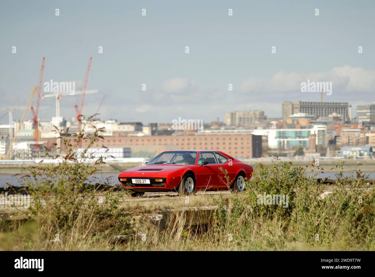 Classic red Ferrari Dino 308 GT4 with a cityscape in the background ...