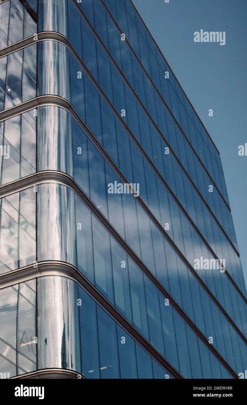 Modern office building glass facade with sky reflection in the windows ...