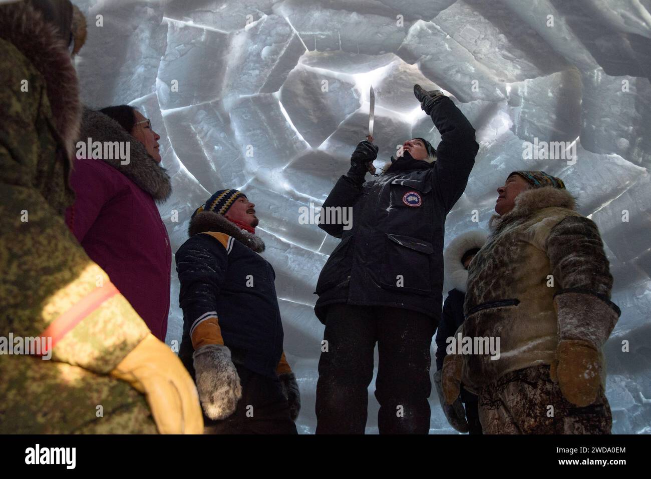 Prime Minister Justin Trudeau helps trim the final block of the igloo ...