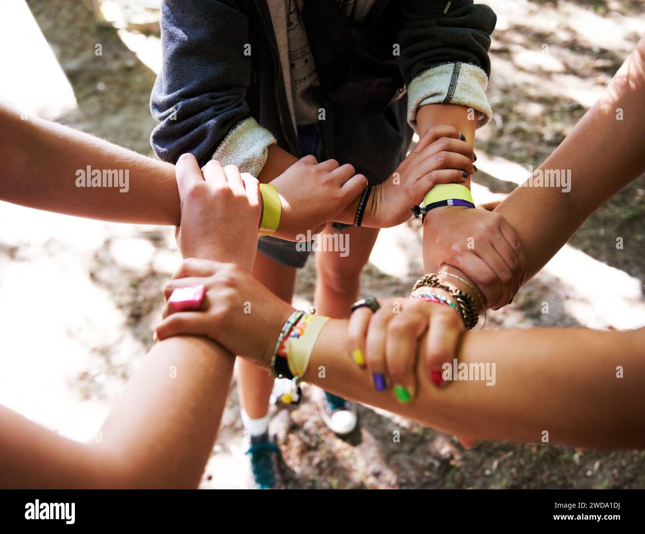 People, hands together and outdoor festival with arm bands for community, teamwork or unity at ...
