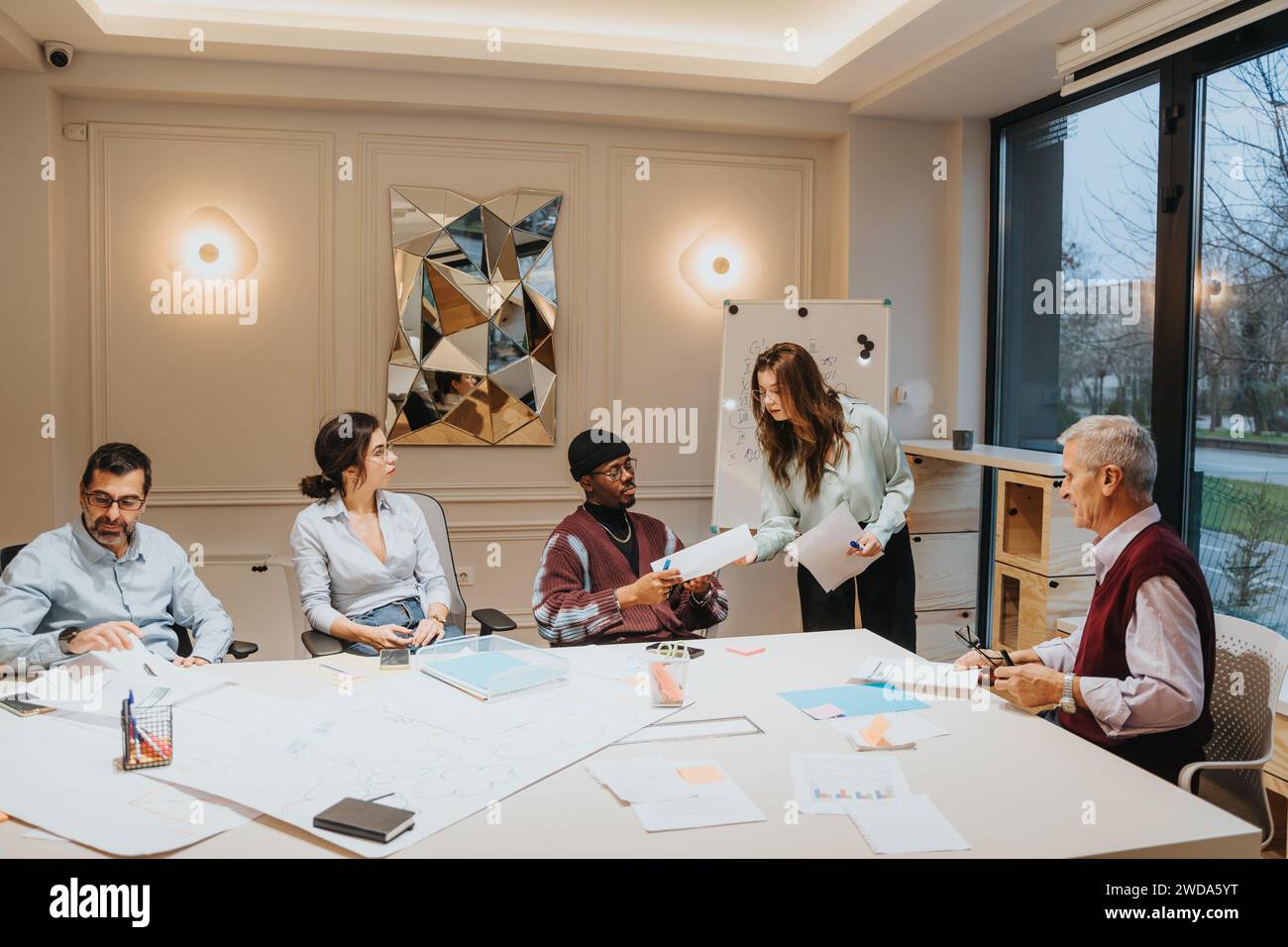 Cross generational, business team collaborating in a modern office ...