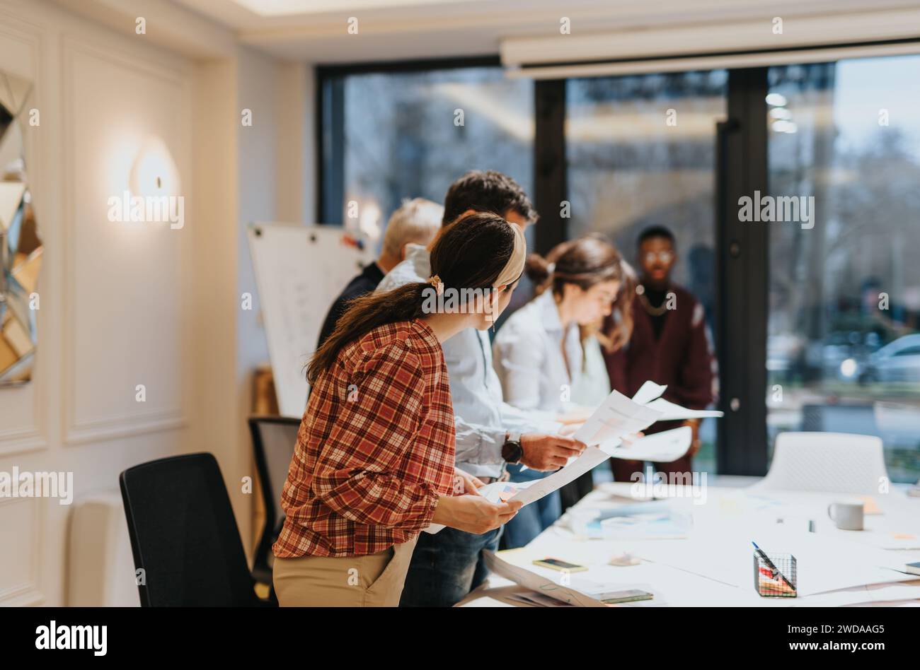 A diverse team of professionals collaborating in an office, focused on ...
