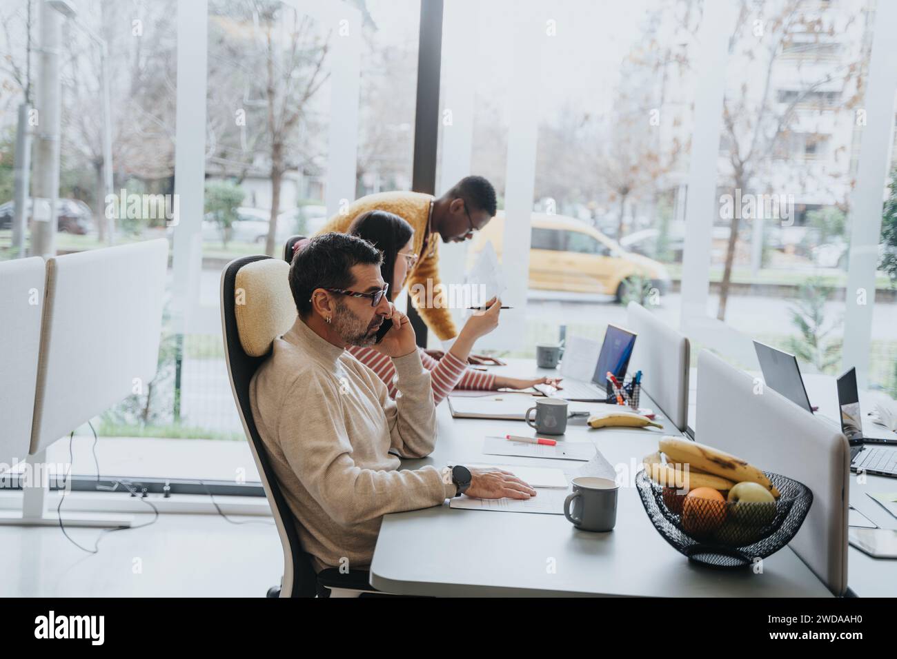 Diverse employees collaborating in a modern office, discussing ...