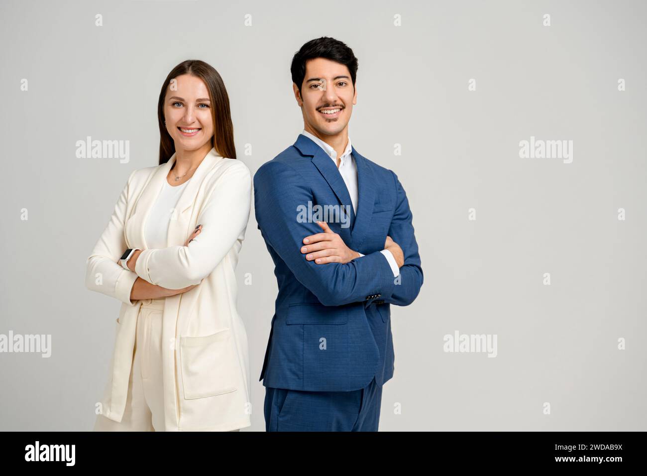 Businesswoman and businessman standing together back-to-back with arms ...