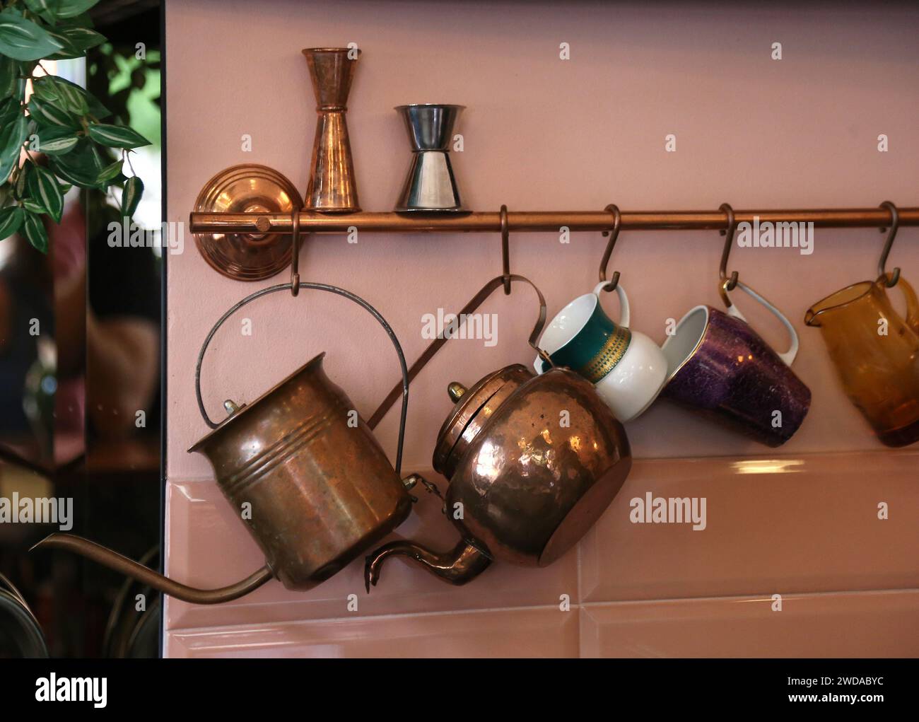 Copper pots hanging on the wall vintage style setup Stock Photo - Alamy