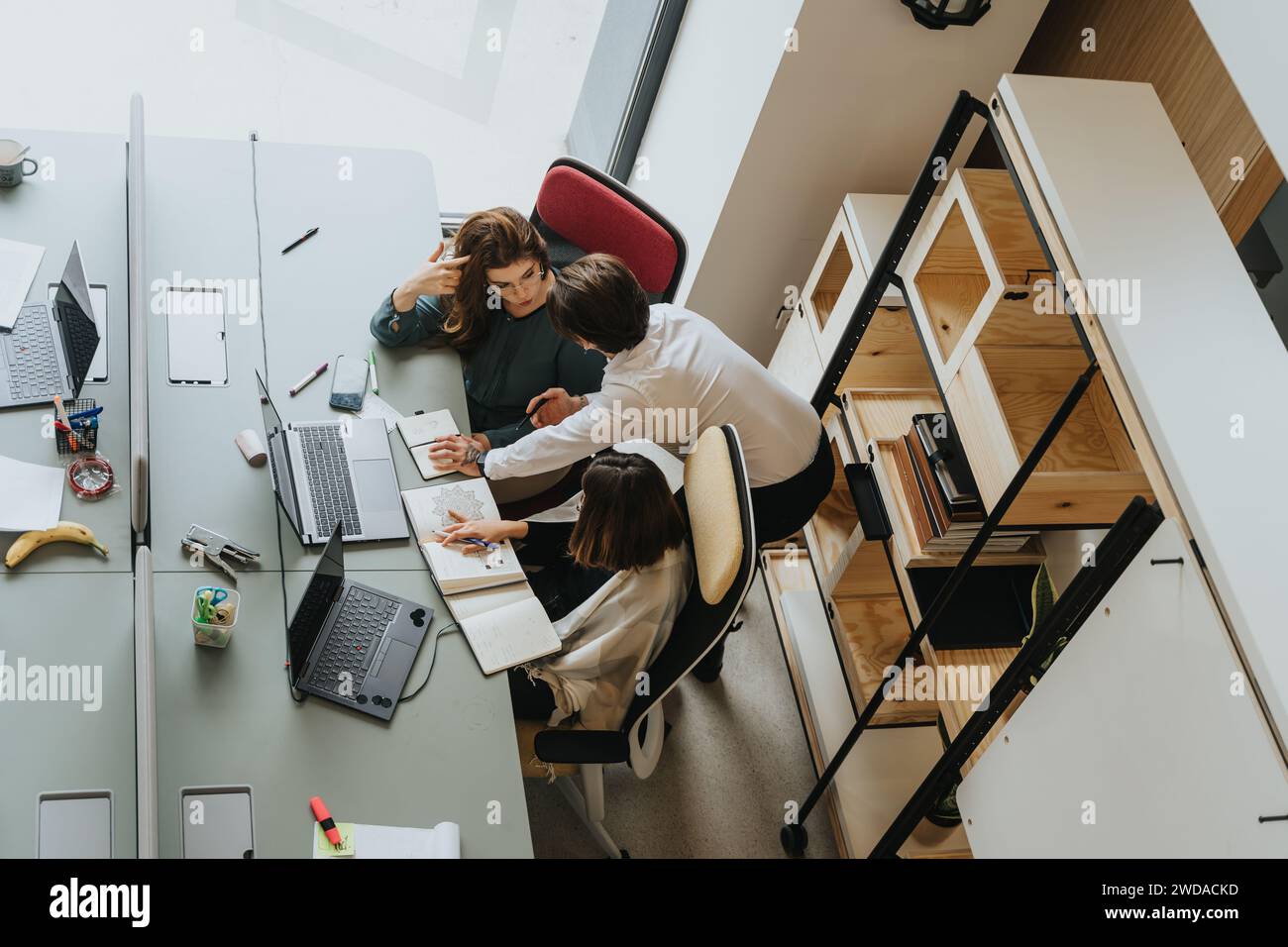 Three enthusiastic coworkers discussing their innovative project in a ...