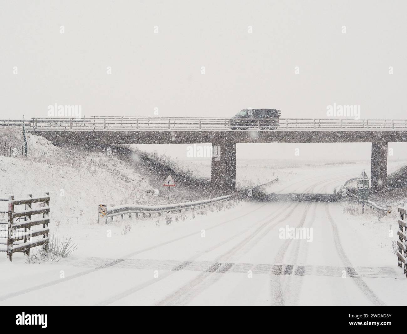 Heavy snow falling on an already snowy scene as a van passes over a ...