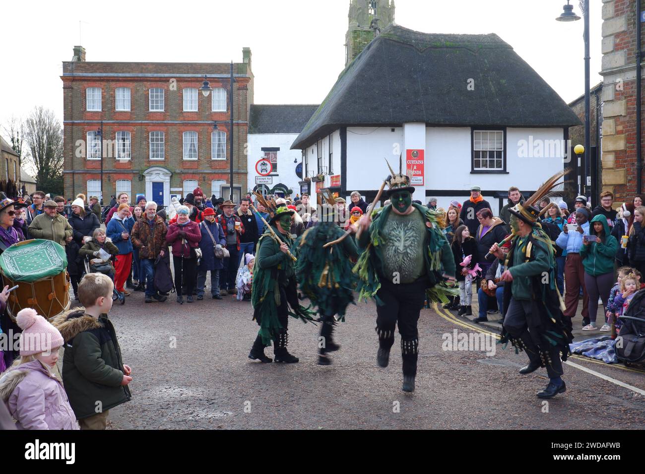 Members of the Sutton Masque Border Morris team dance with green ...