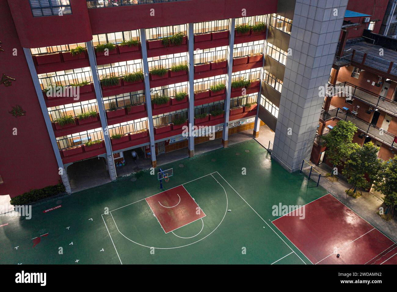 The middle school playground at night is illuminated by the indoor lights of the teaching ...