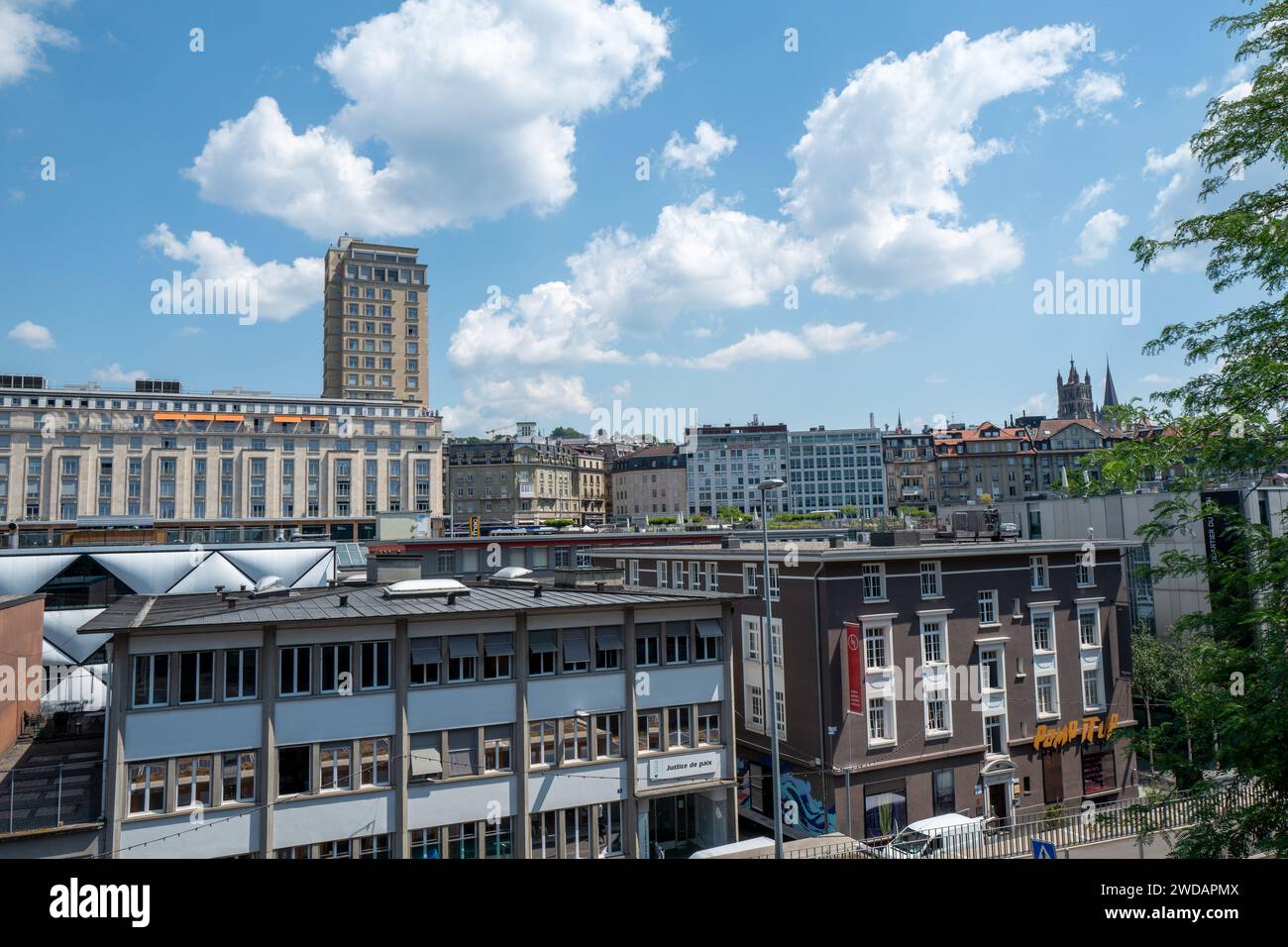 A clock tower stands tall behind a building adorned with windows Stock ...