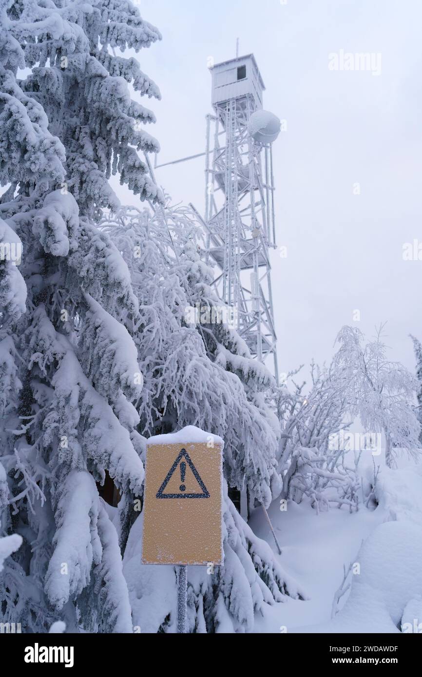 Yellow warning sign in front of a frozen watchtower in winter Stock ...