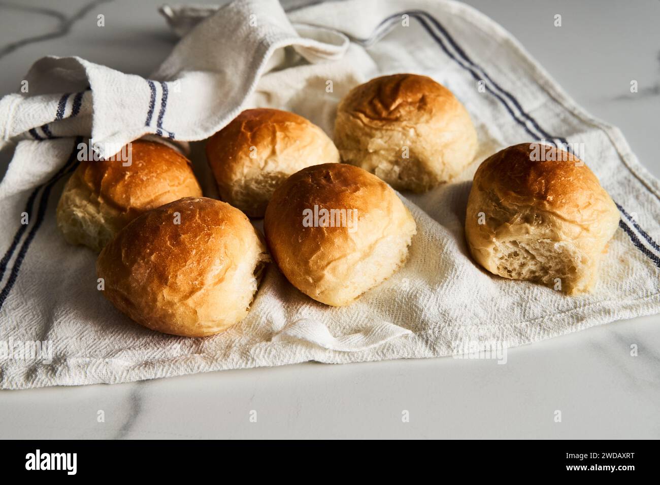 Burger Buns or mini buns on white marble background and kitchen towel ...
